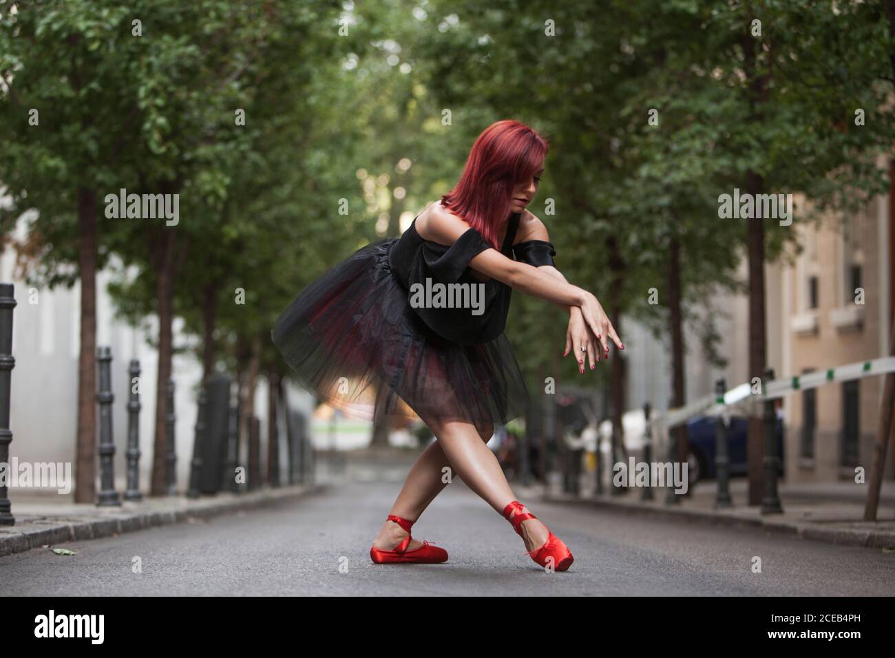 Red head ballerina with black tutu and red ballet tips dancing on the ...