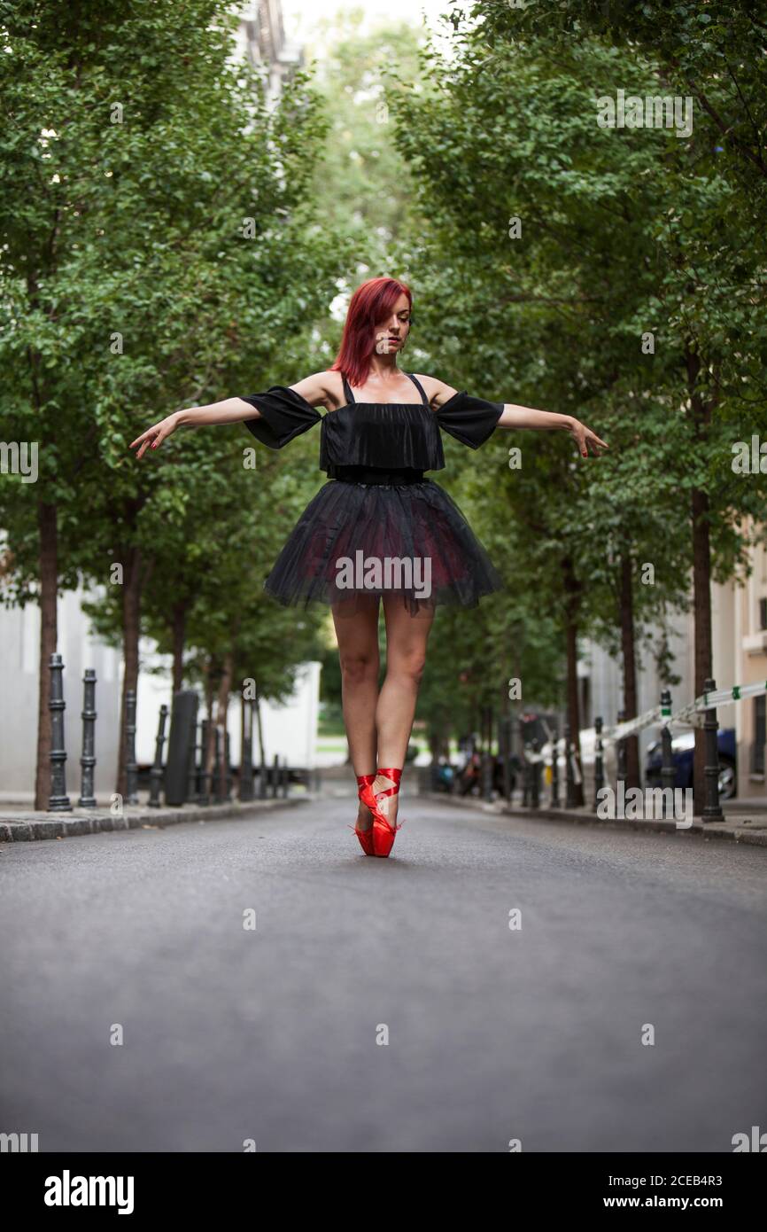 Red head ballerina with black tutu and red ballet tips dancing on the ...