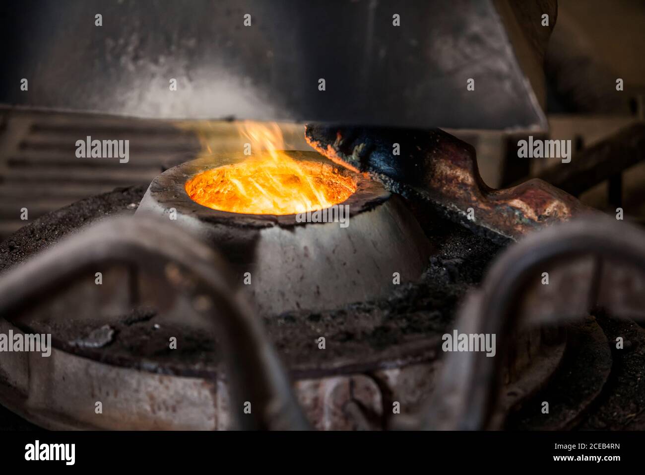 Crop view of blacksmith furnace with a burning fire in metal casting ...