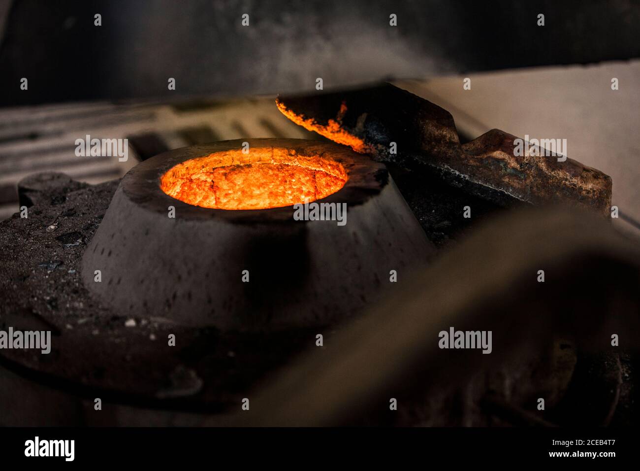 Crop view of blacksmith furnace with a burning fire in metal casting ...
