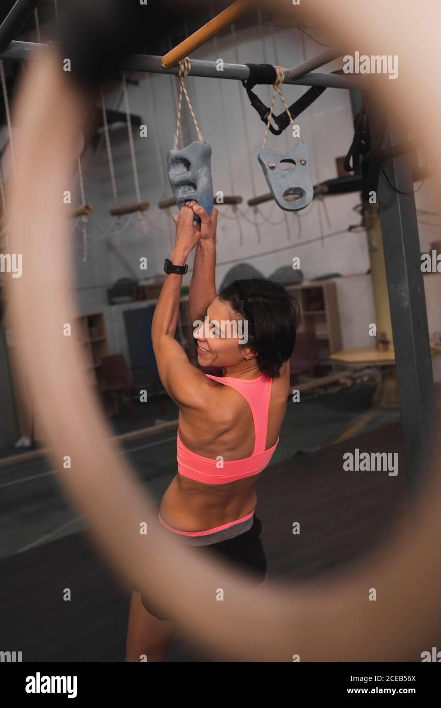 Young slim sportive lady in sportswear doing pull up exercises on ...