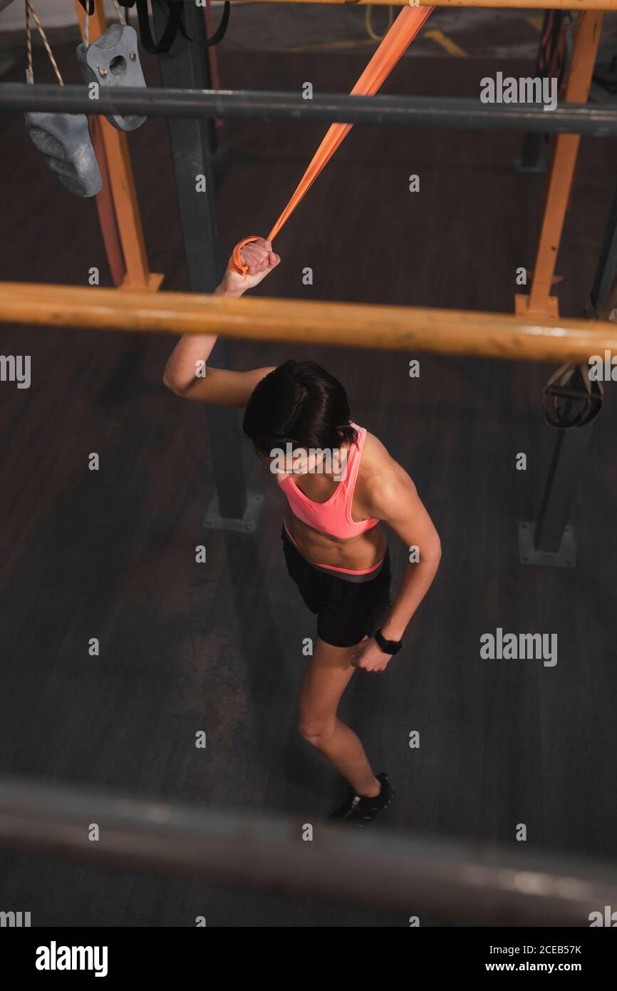 Young slim sportive lady in sportswear doing pull up exercises on ...