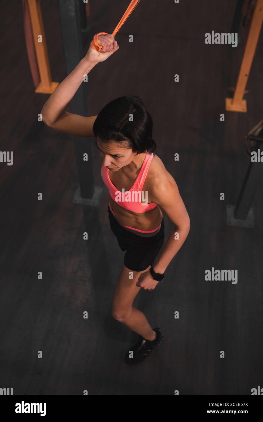 Young slim sportive lady in sportswear doing pull up exercises on ...