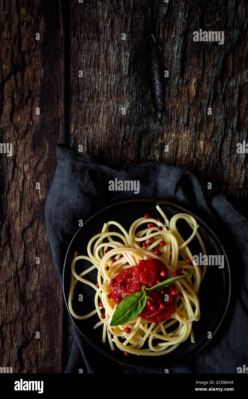 Spaghetti with tomato sauce. On dark background. Flat lay.From above ...