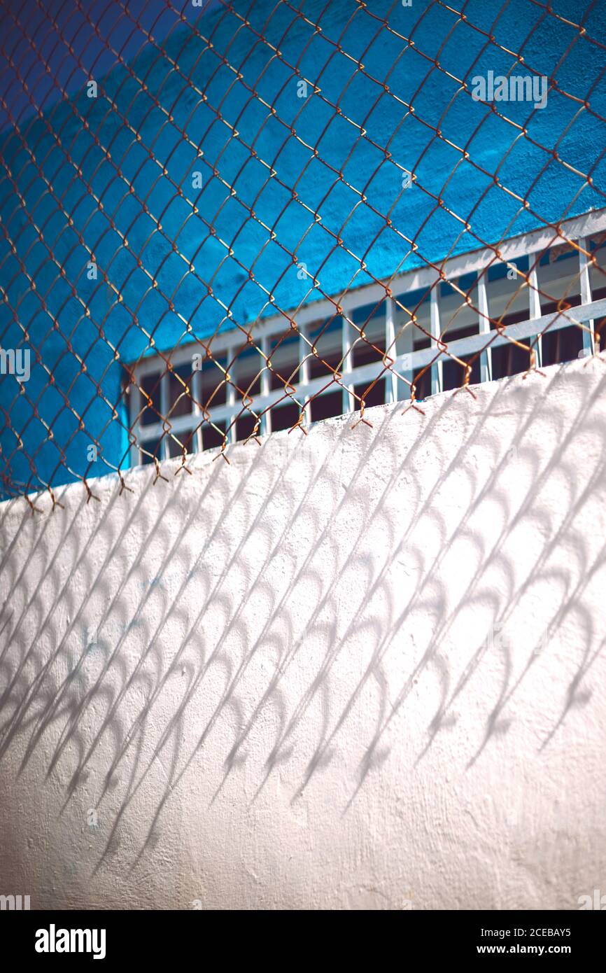 High concrete and net fence standing around secured building in Mexican ...