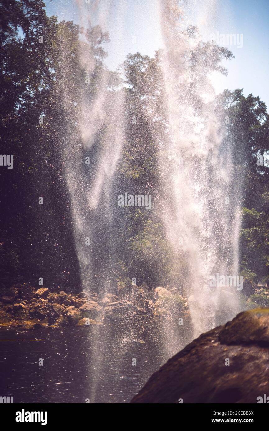 Breathtaking view of thin stream of water falling from cliff in ...