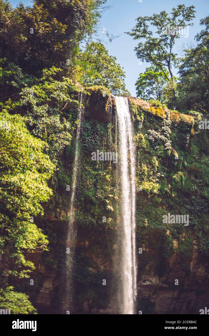 Breathtaking view of thin stream of water falling from cliff in ...