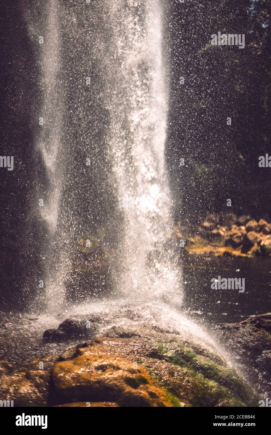 Breathtaking view of thin stream of water falling from cliff in ...