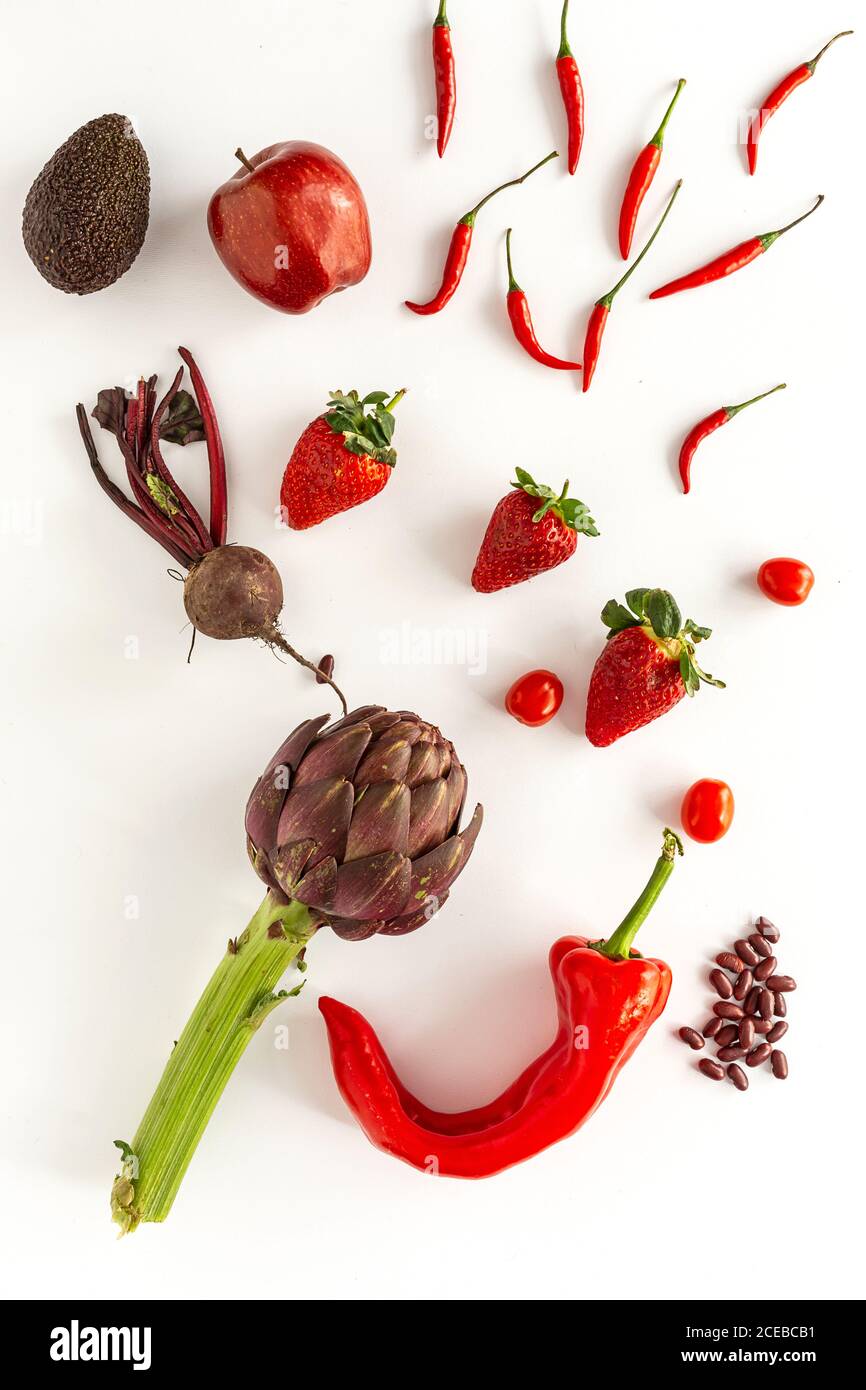 Mix of fruits and vegetables in red color on white background. Healthy ...