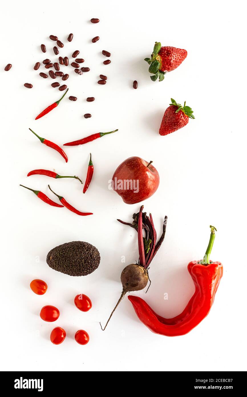 Mix of fruits and vegetables in red color on white background. Healthy ...