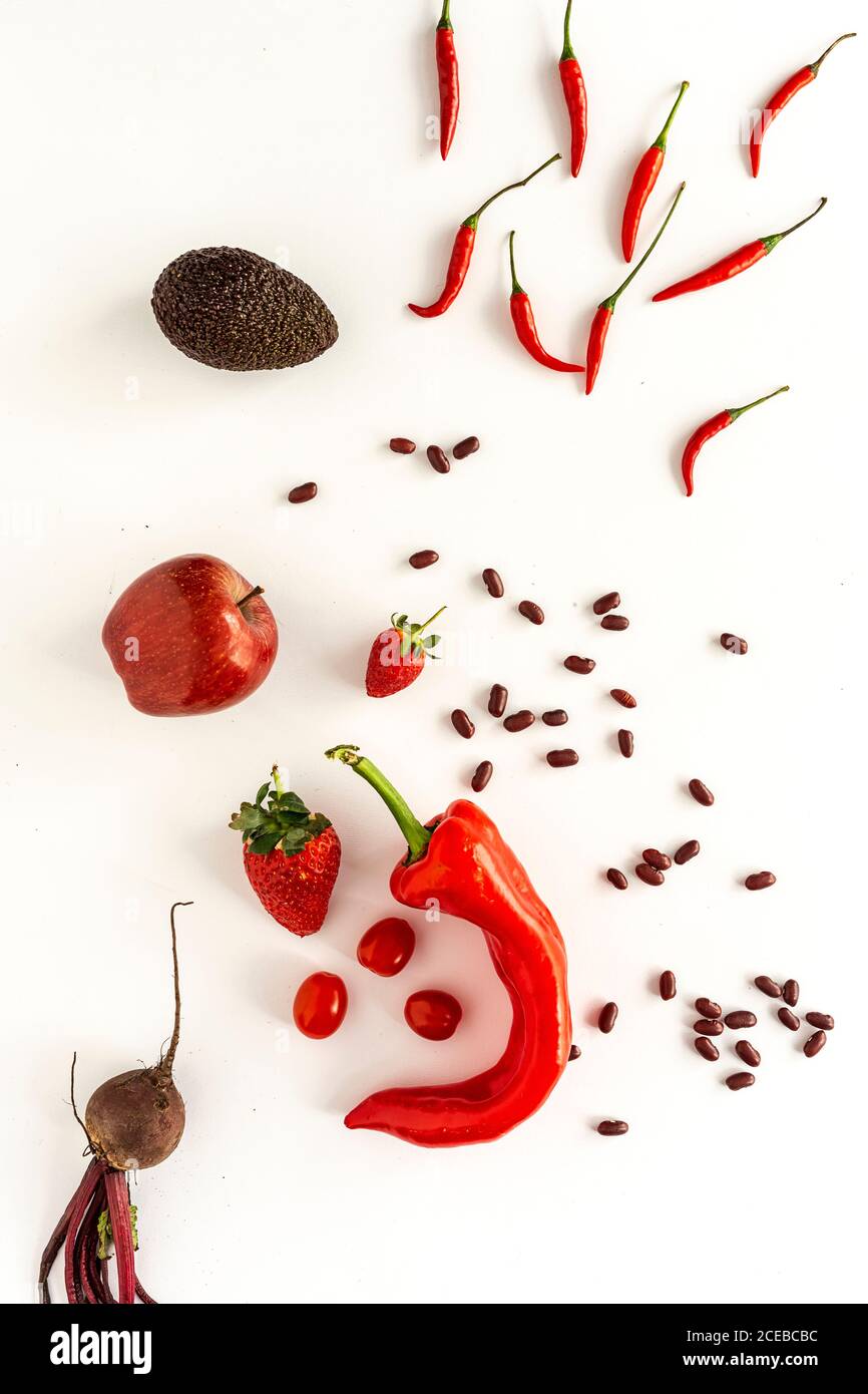 Mix of fruits and vegetables in red color on white background. Healthy ...