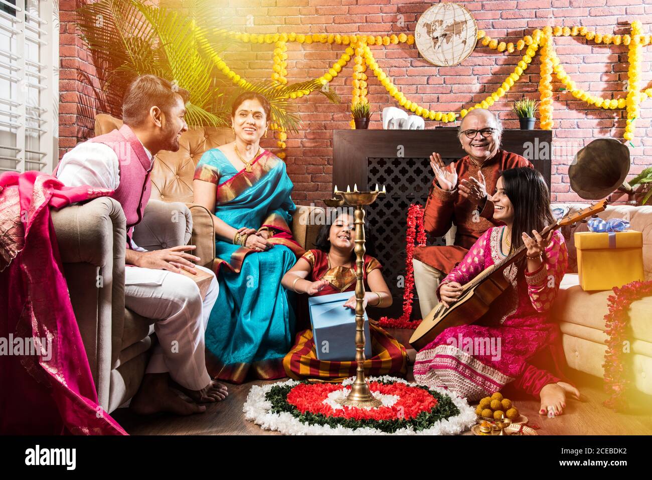 Indian family singing and playing guitar on diwali festival ...