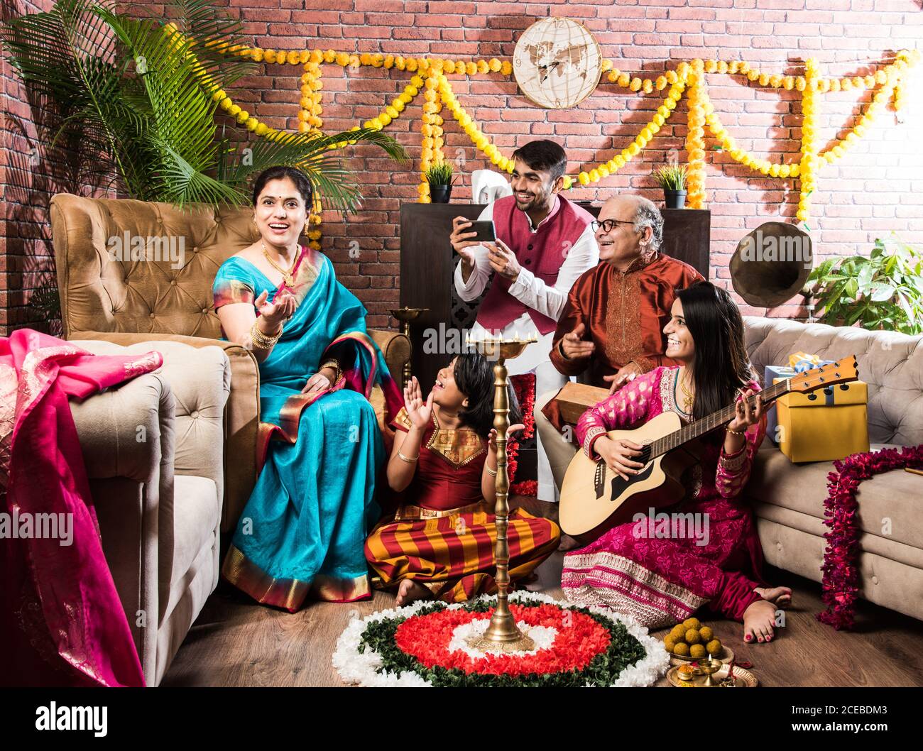 Indian family singing and playing guitar on diwali festival ...