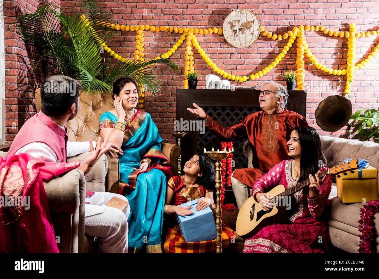 Indian family singing and playing guitar on diwali festival ...