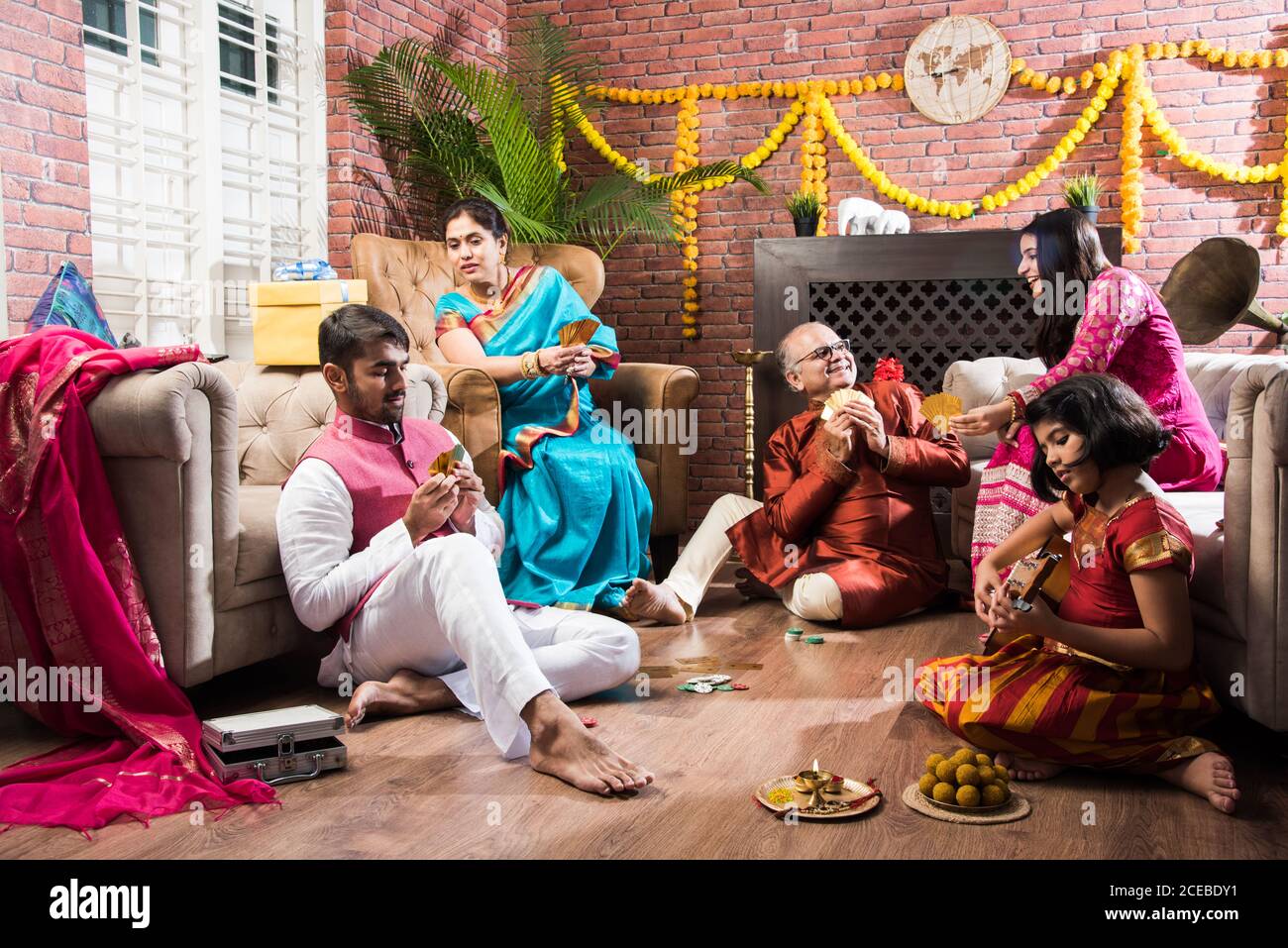 Happy Indian Family playing teen patti or three Cards game on diwali ...