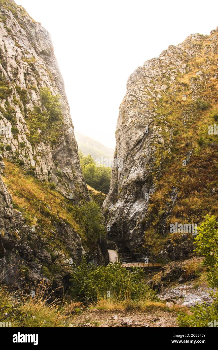 Small wooden path going between two rough stony cliffs in majestic ...