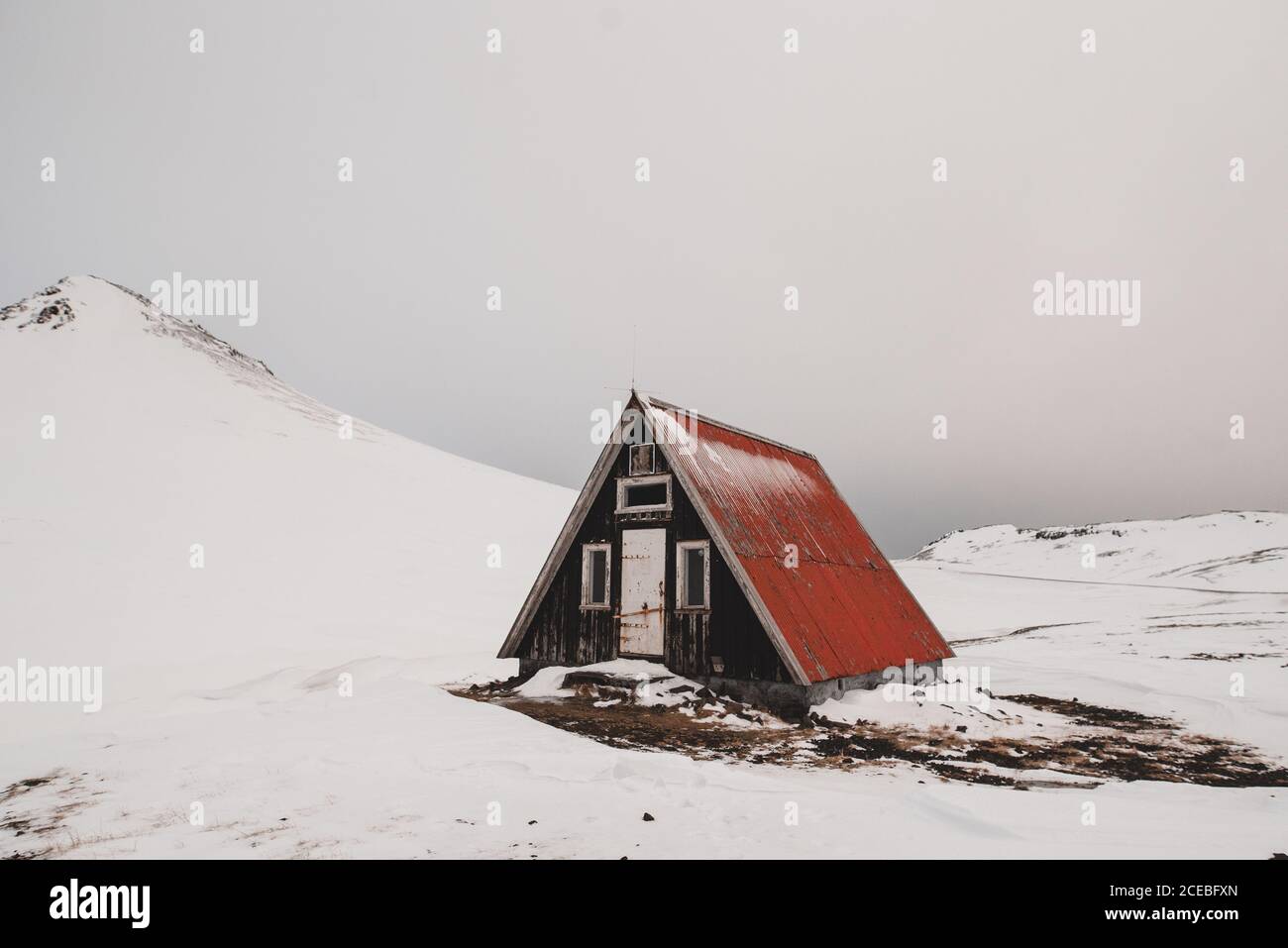 Small hut standing amidst snow in gray winter day in amazing Icelandic ...