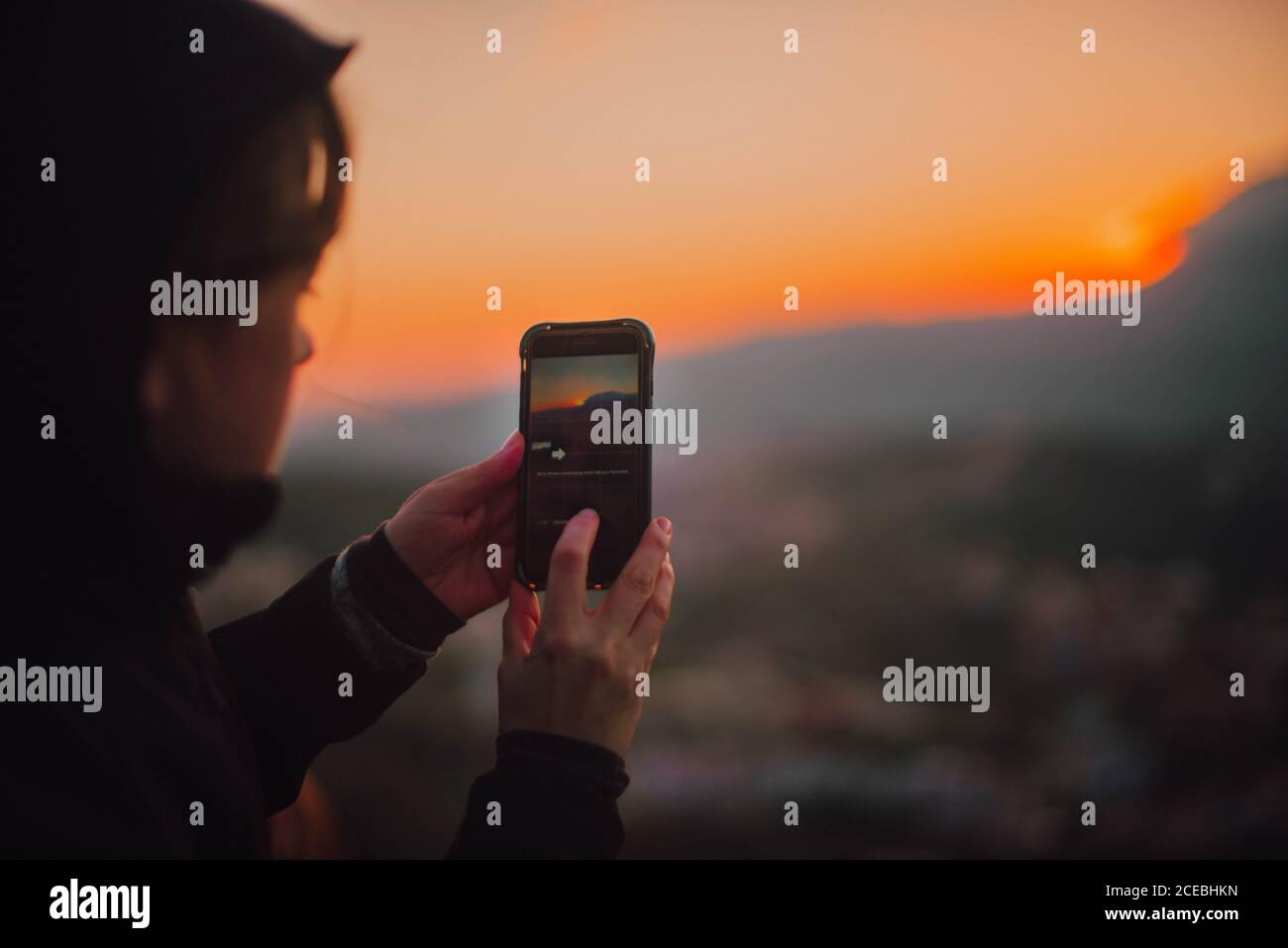 Back view of woman taking photo of sunset hi-res stock photography and ...