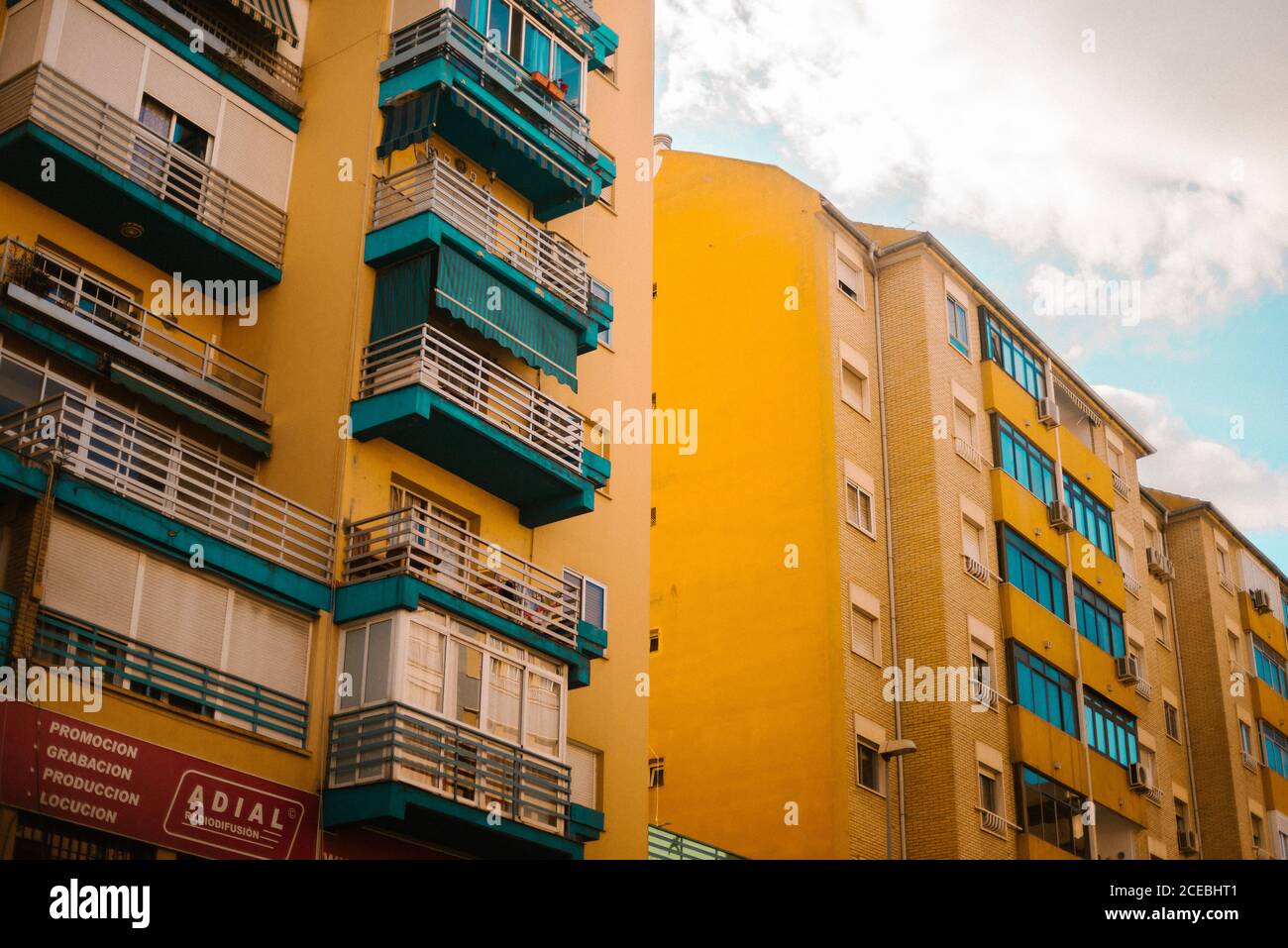 Wonderful cloudy sky over bright yellow building on street of Malaga ...