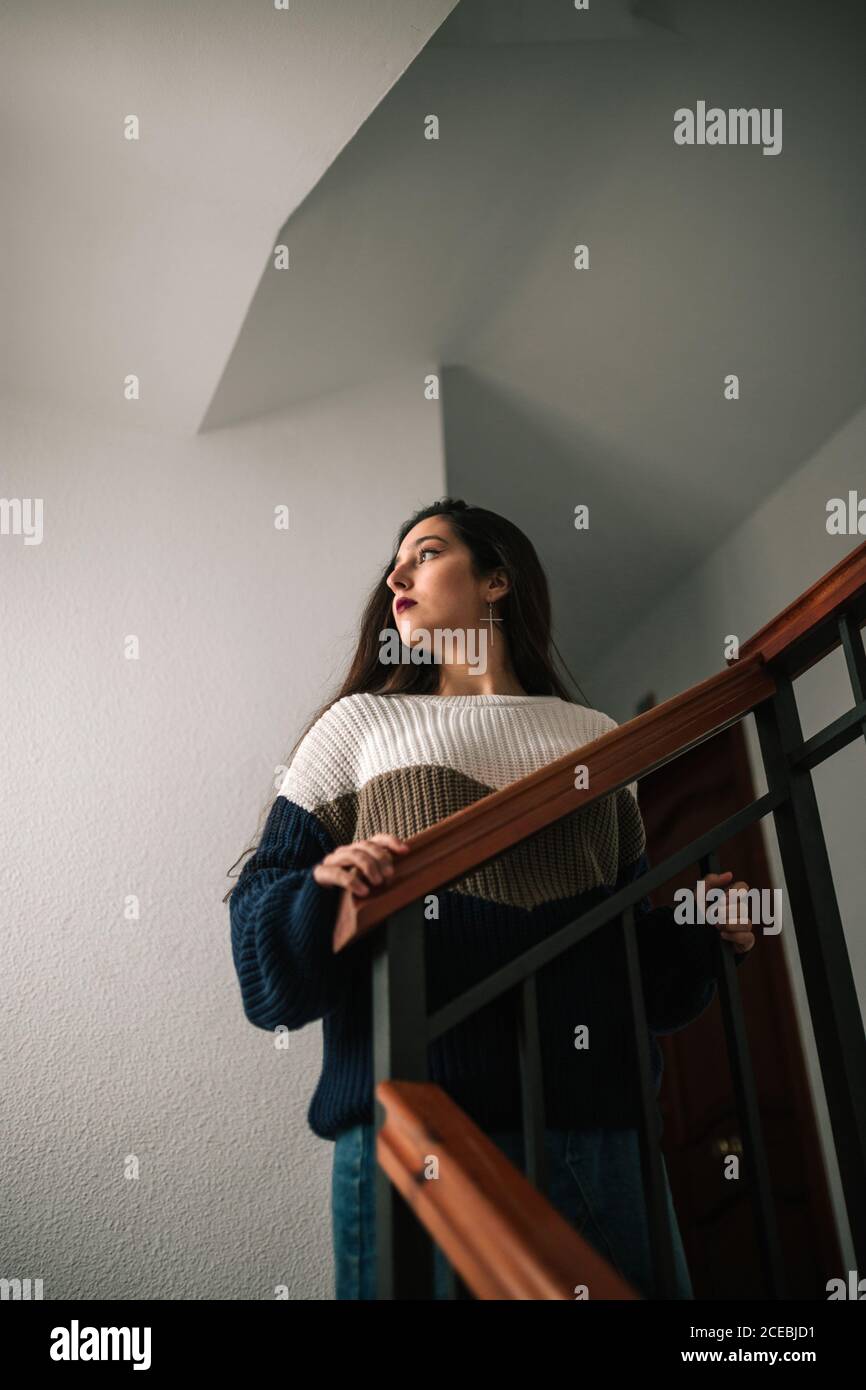 thoughtful teenage girl on the stairs of the interior of a building ...