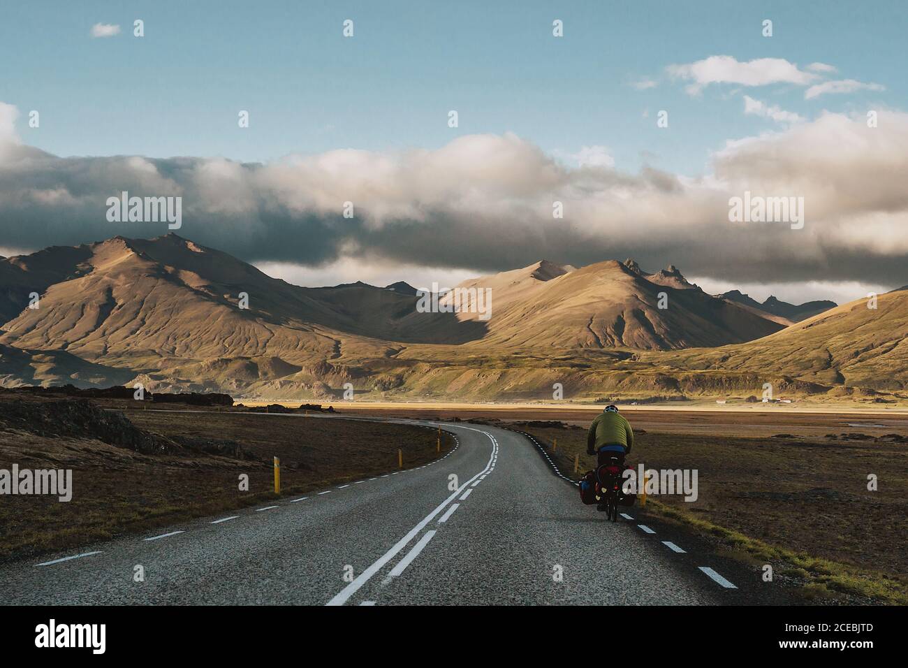 Back view of traveler riding on motorcycle on the road in hillside ...