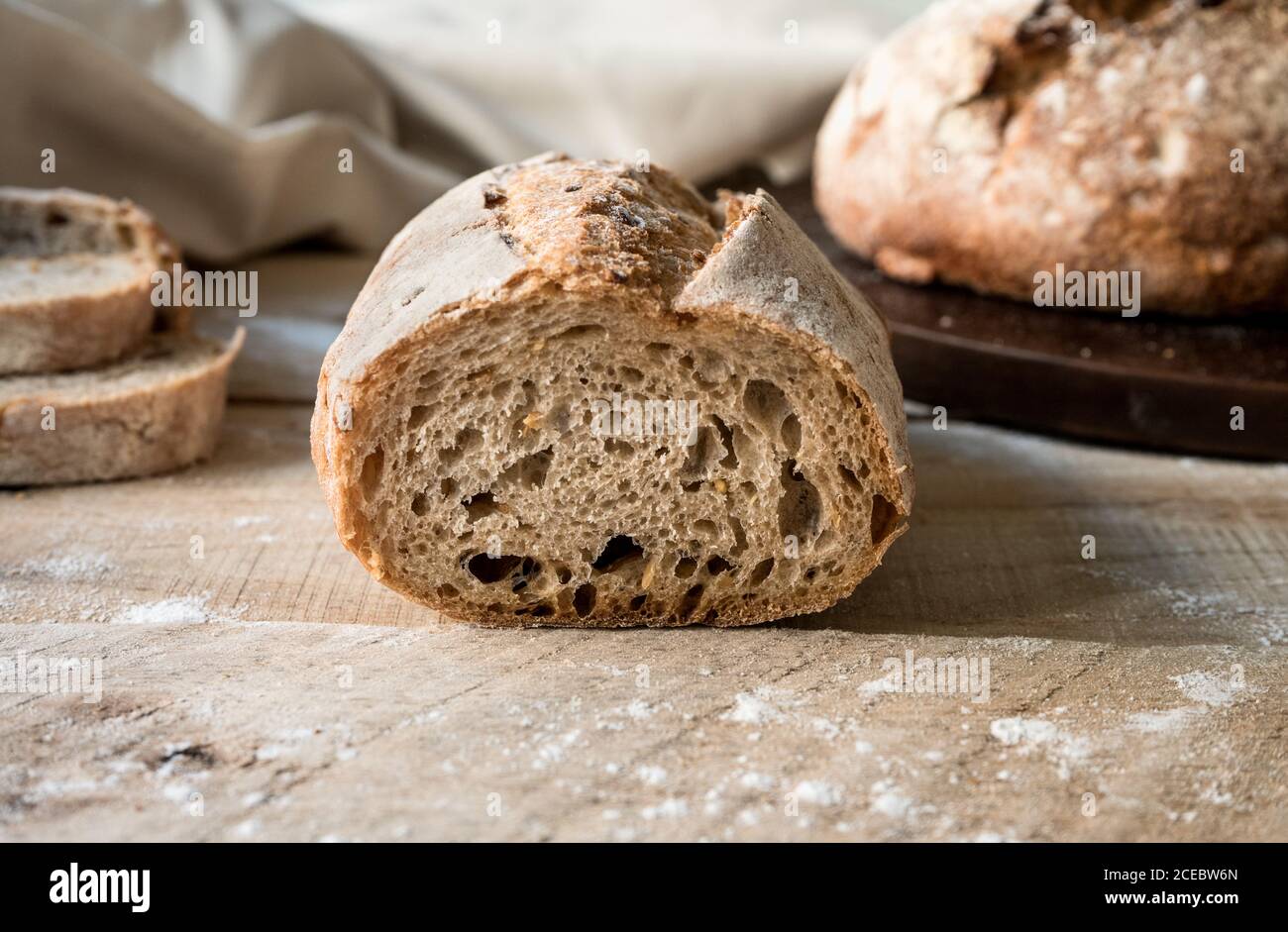 Loaf of fresh baked cut rye bread in flour on a table Stock Photo - Alamy