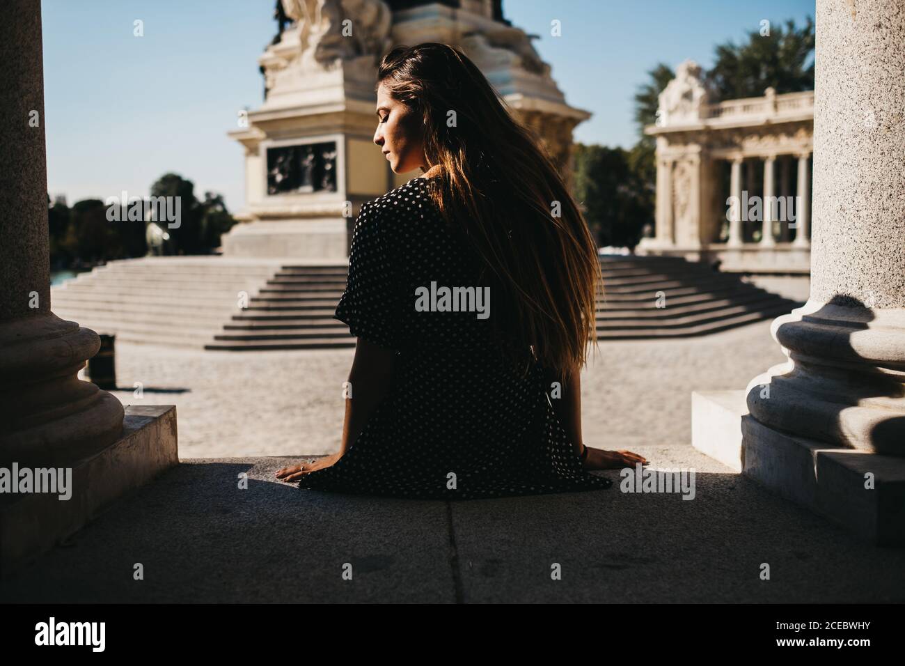 Pretty Woman sitting near column Stock Photo - Alamy
