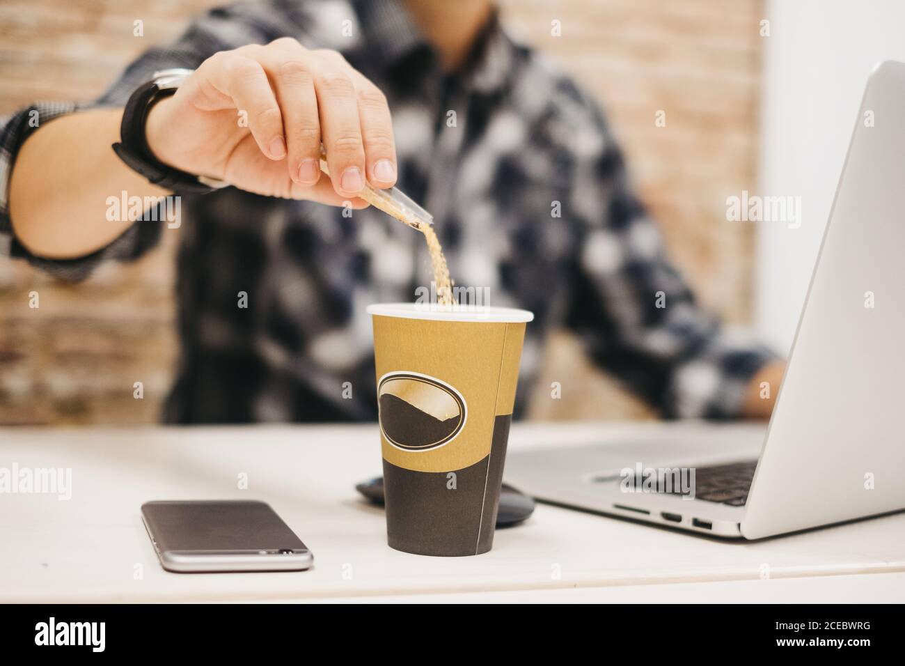 Crop man throwing sugar in coffee Stock Photo - Alamy