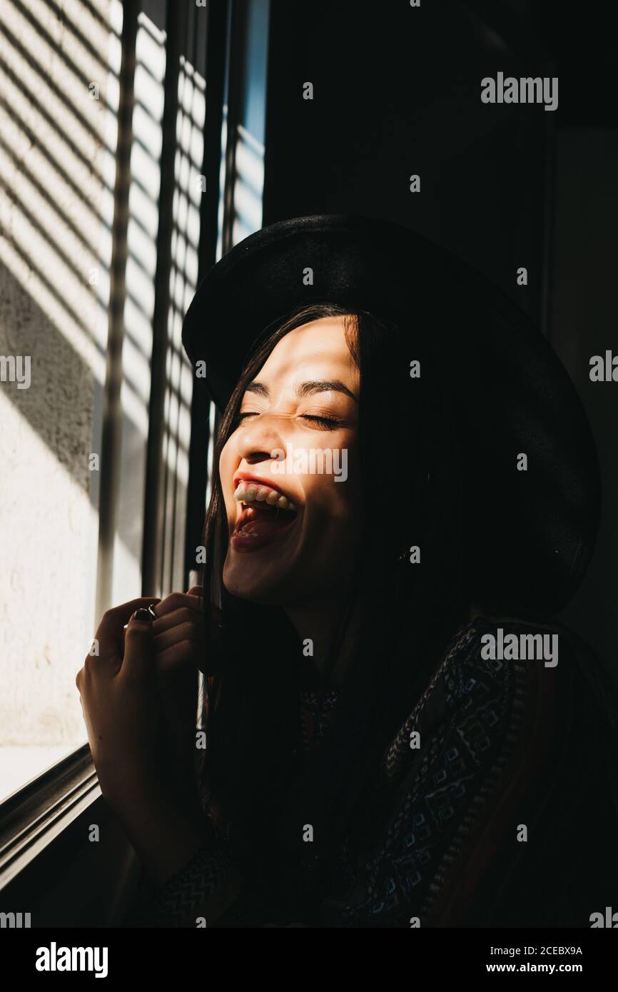 Lovely young female keeping eyes closed and supporting head while ...