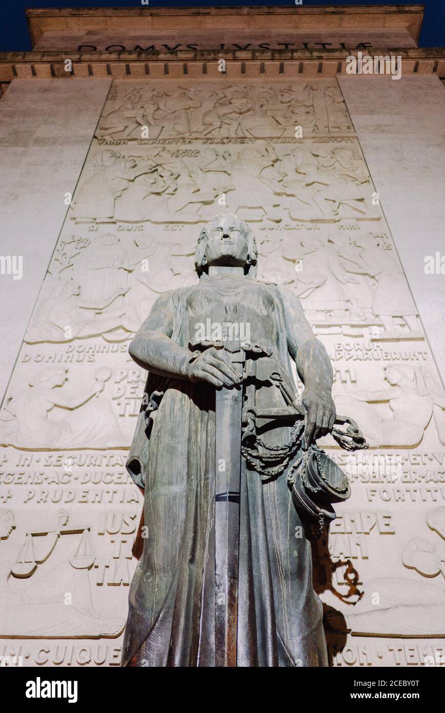 From below big statue holding sword at illuminated wall Stock Photo - Alamy