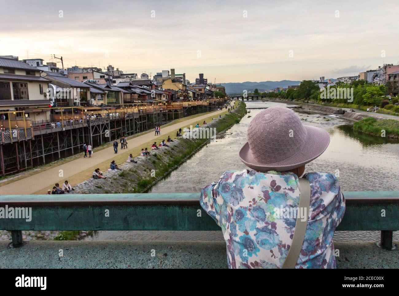 Japan - May, 10 2013: Back view of person leaning on bridge railing and ...