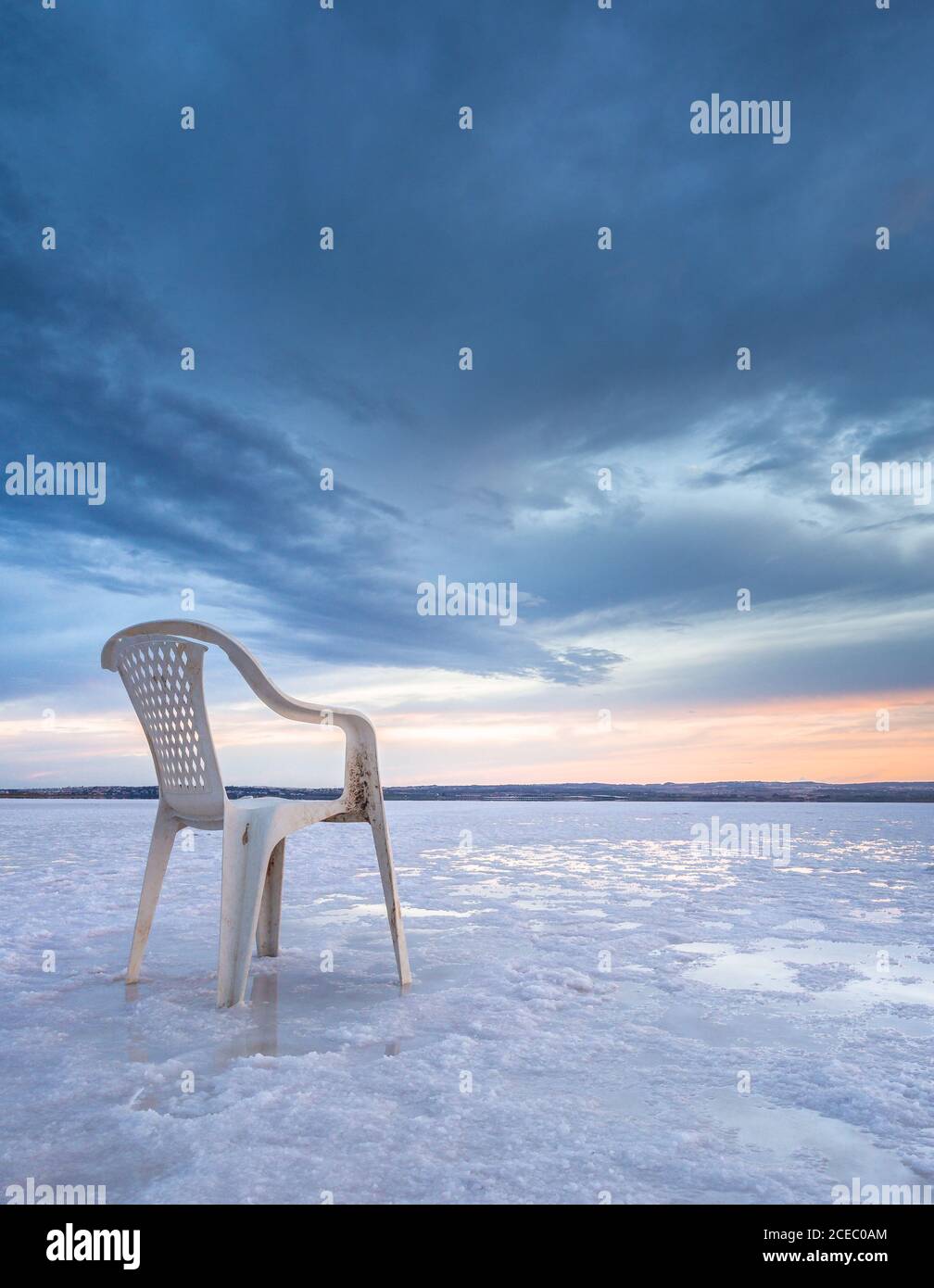 Chair on salt mine during sunset Stock Photo - Alamy