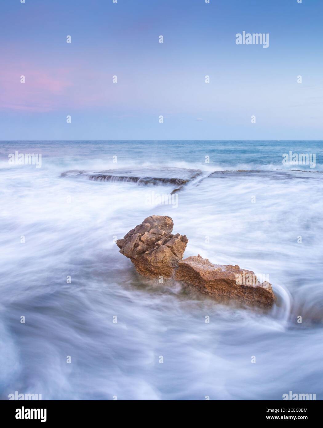 Amazing stones on shore near water and blue sky Stock Photo - Alamy