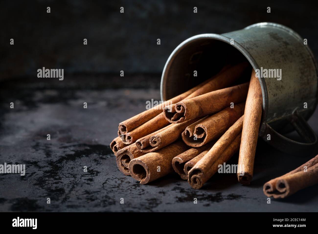 Cinnamon sticks in a vintage tin container on dark shabby disstressed ...