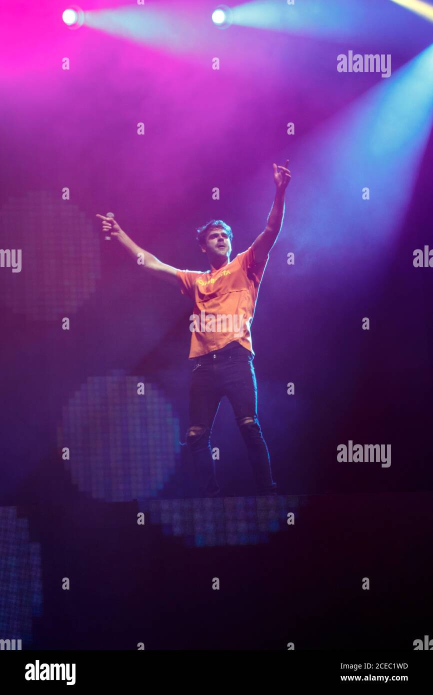 Singer on stage with arms up Stock Photo - Alamy
