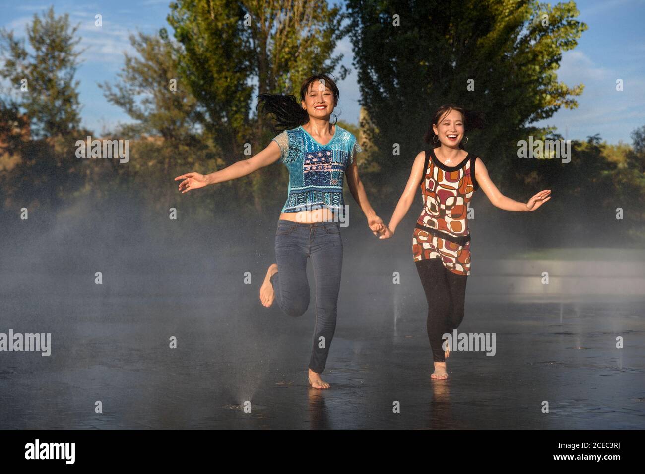 Asian women jumping on fountain water Stock Photo - Alamy