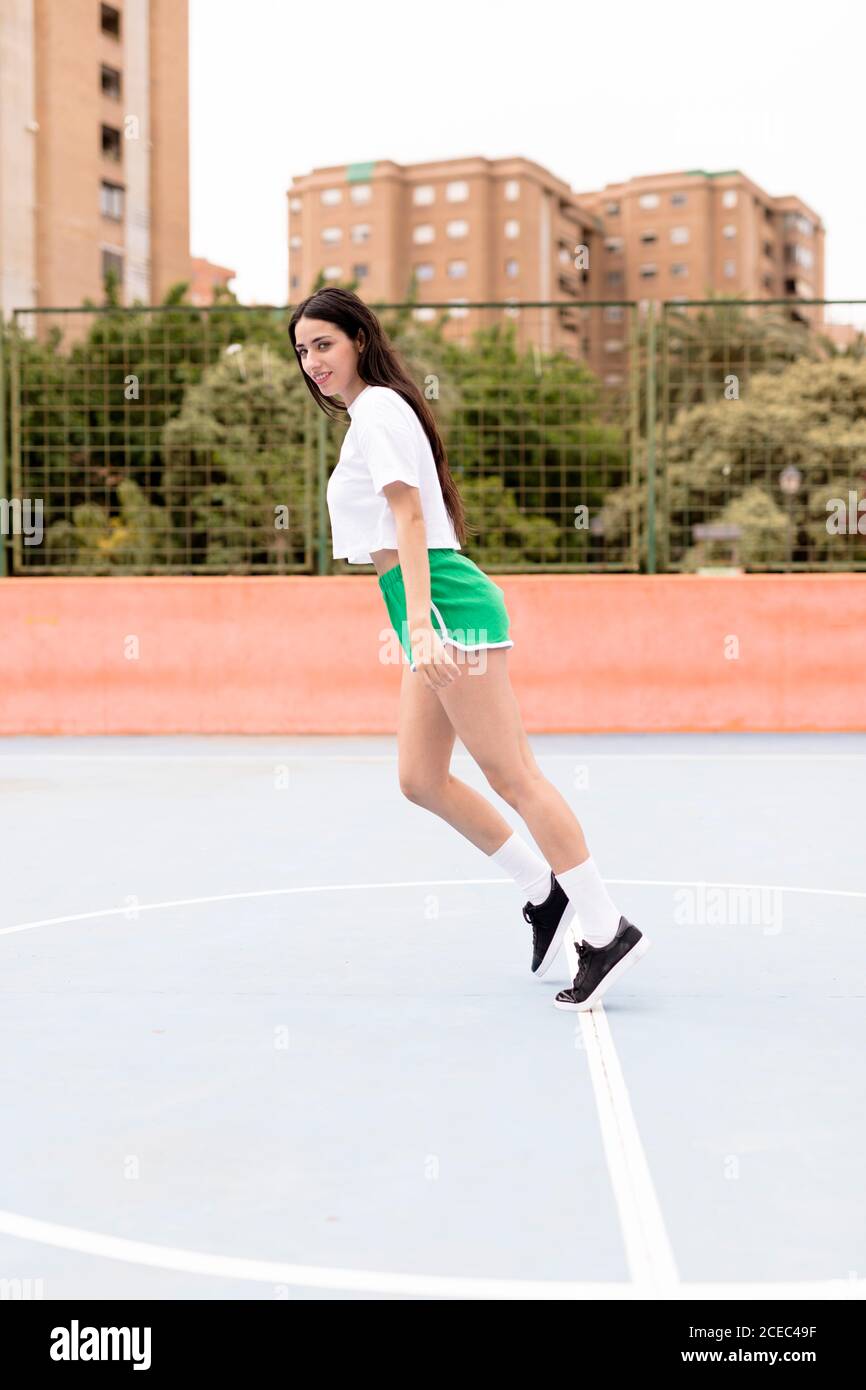 Young slim Woman leaning forward on sports ground Stock Photo - Alamy