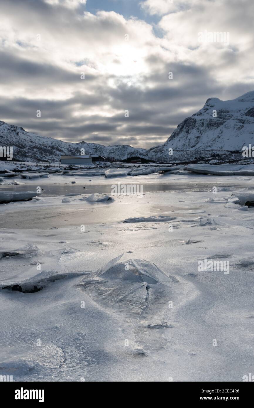 Cracked ice layer on water with mountains Stock Photo - Alamy