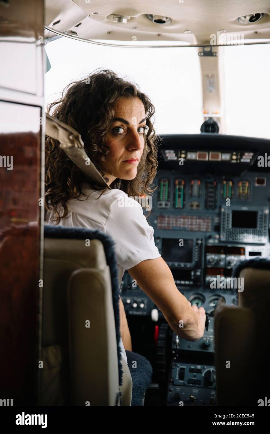 Brunette Woman navigating plane Stock Photo - Alamy