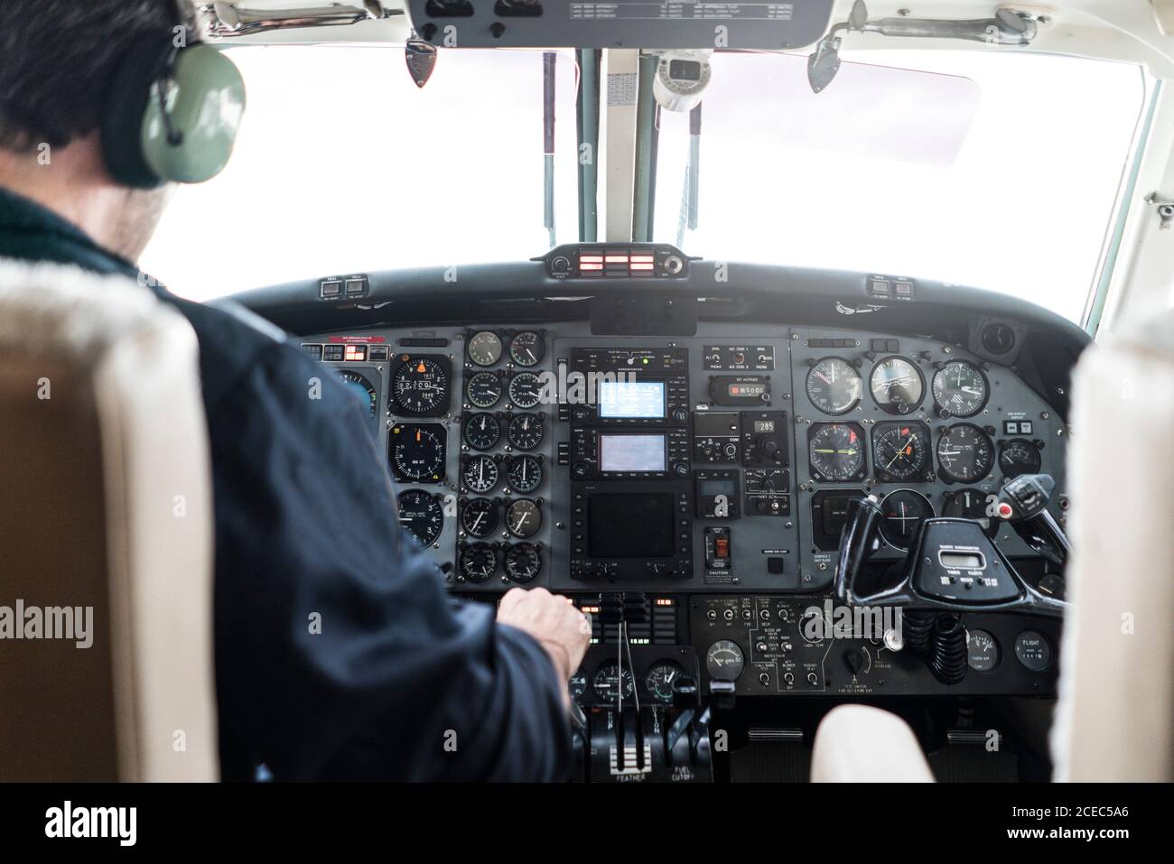 unrecognizable man in headset piloting plane?alone while sitting in ...