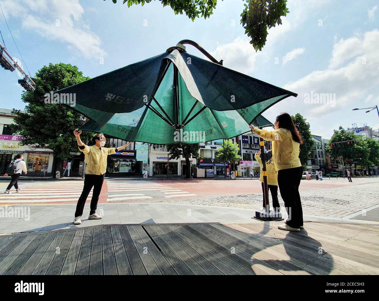 01st Sep, 2020. Prep for typhoon Officials fold a shade canopy for ...
