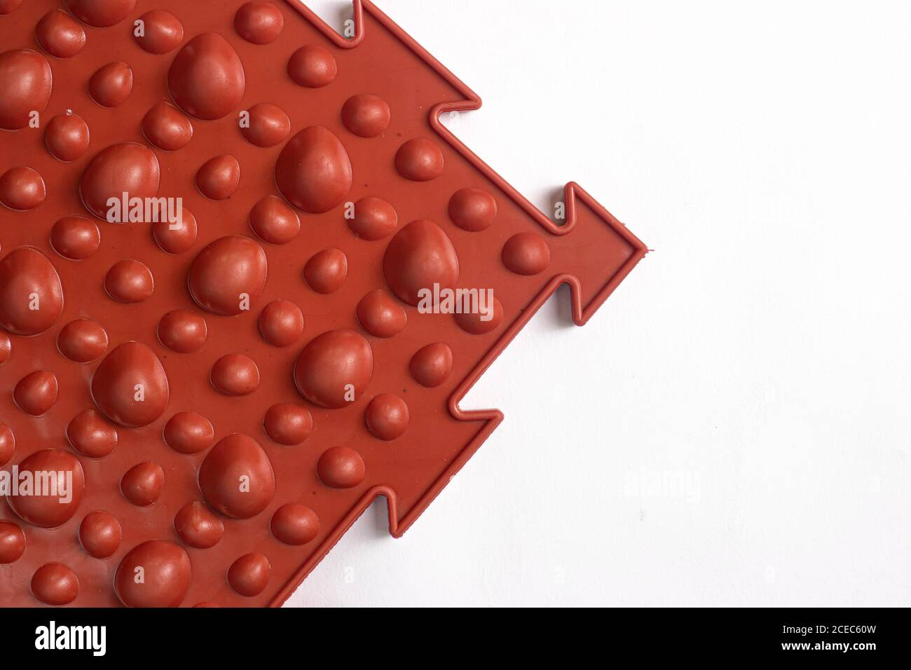Brown orthopedic mat in the form of small stones on a white background ...