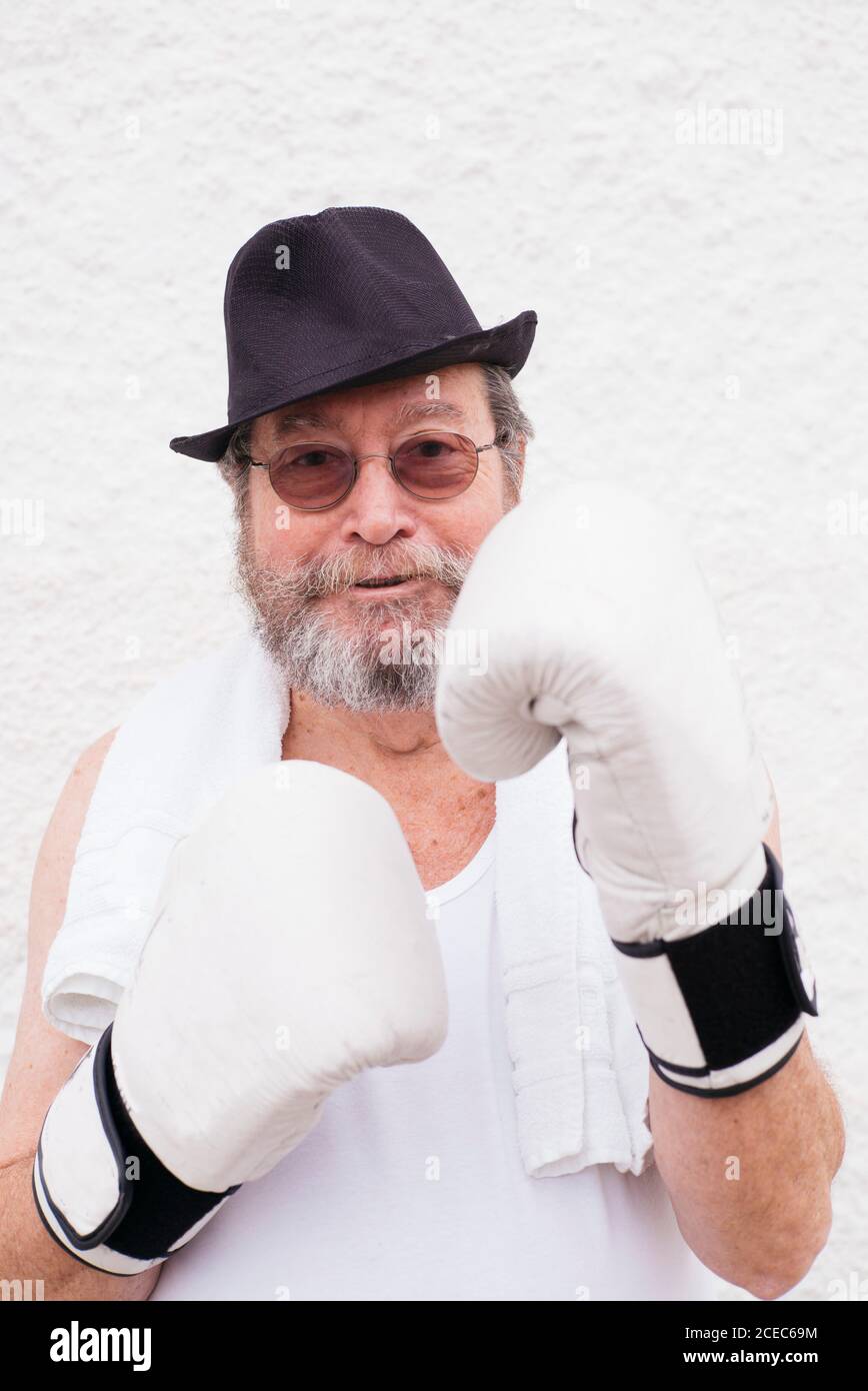 Adult man in hat and white boxing gloves at rough wall Stock Photo - Alamy