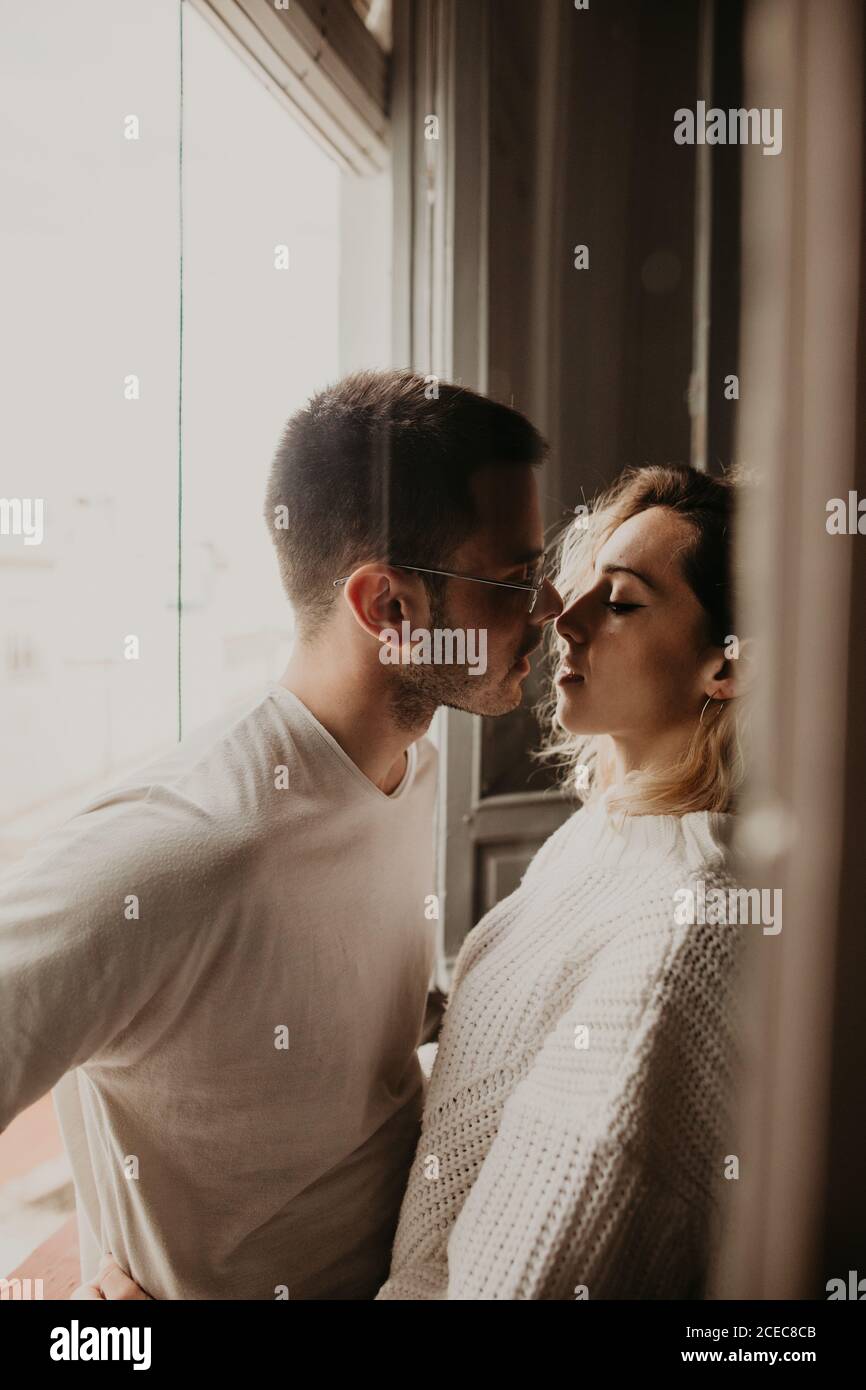 Side view of couple embracing and bonding at home Stock Photo - Alamy