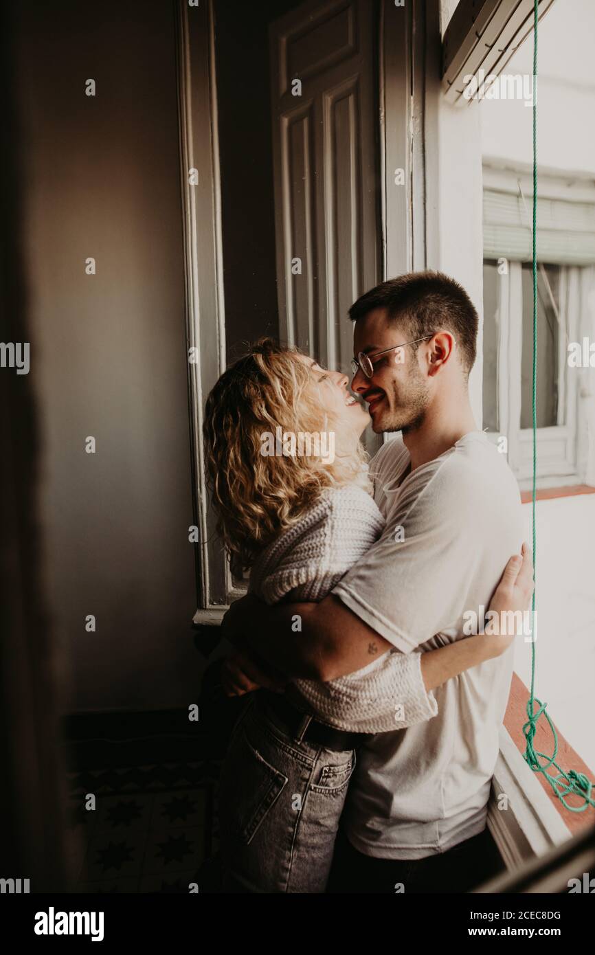 Side view of couple embracing and bonding at home Stock Photo - Alamy