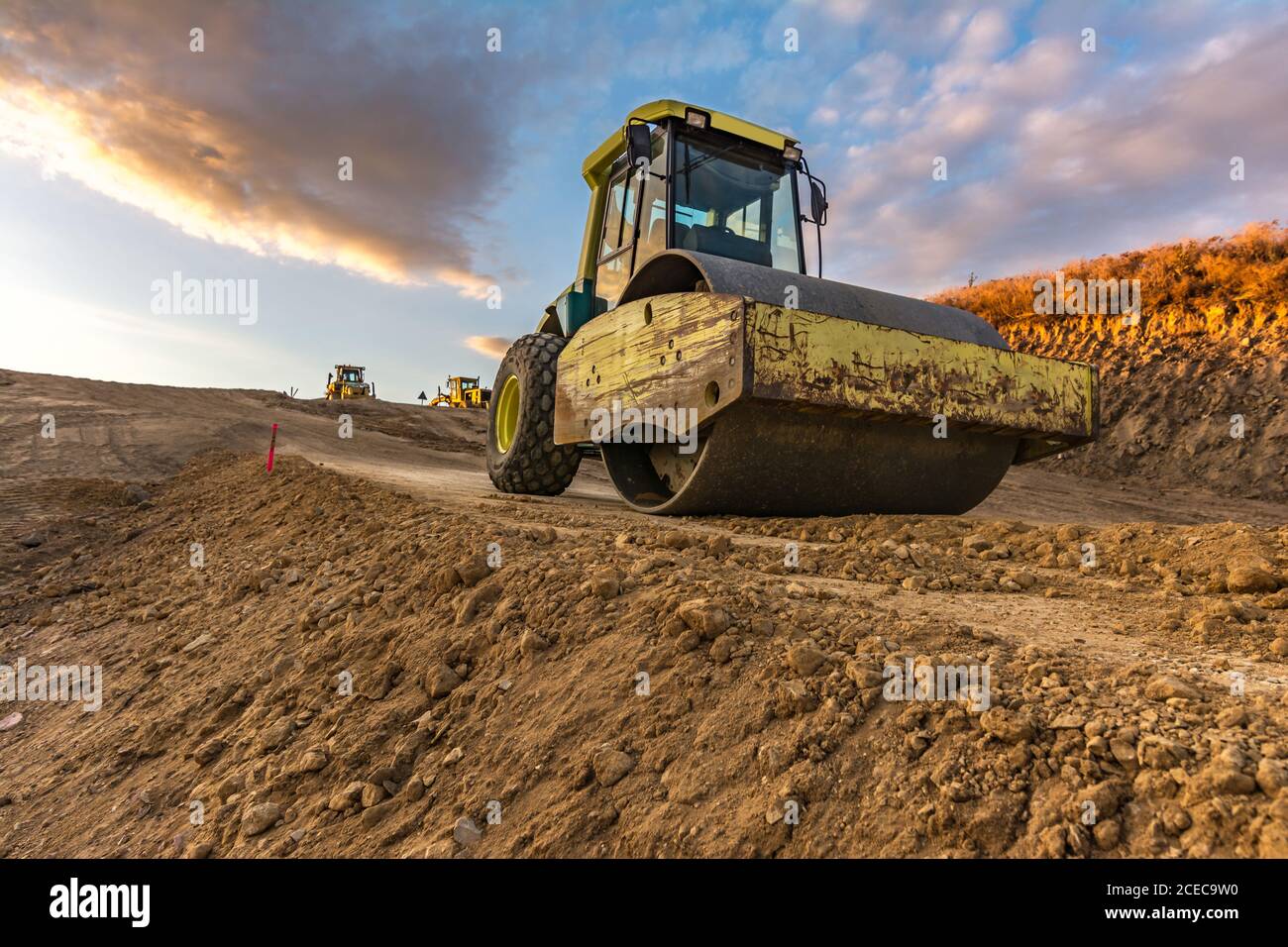 Yellow steamroller on asphalt road in sunlight Stock Photo - Alamy