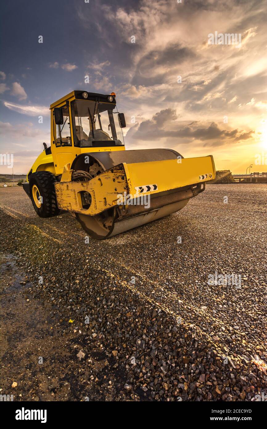 Yellow steamroller on asphalt road in sunlight Stock Photo - Alamy