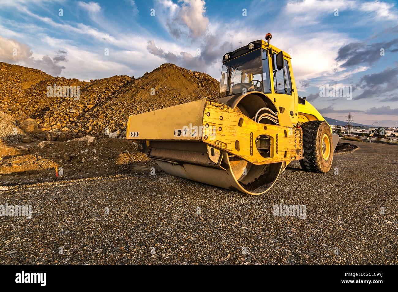 Yellow steamroller on asphalt road in sunlight Stock Photo - Alamy