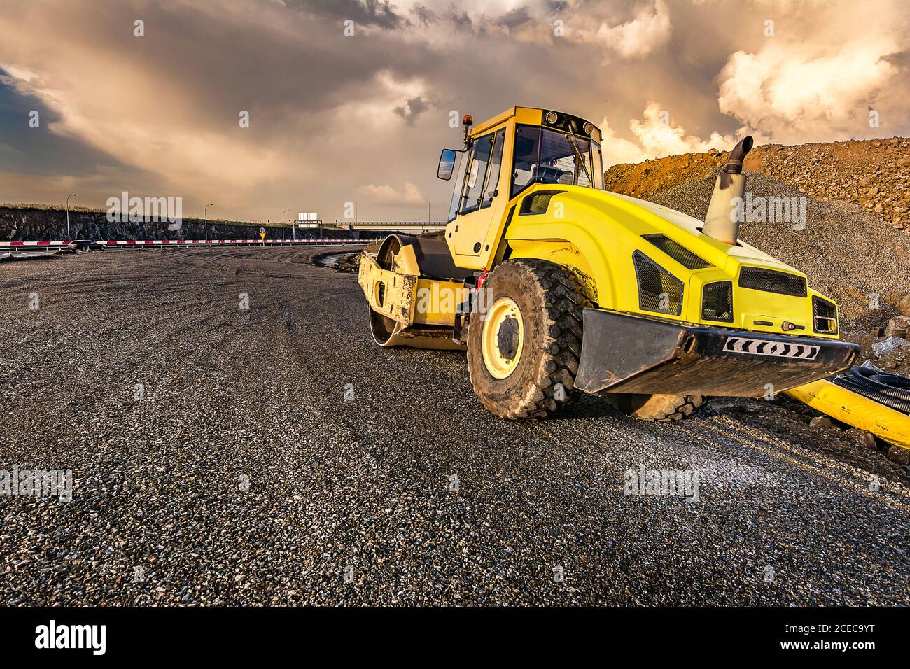 Yellow steamroller on asphalt road in sunlight Stock Photo - Alamy
