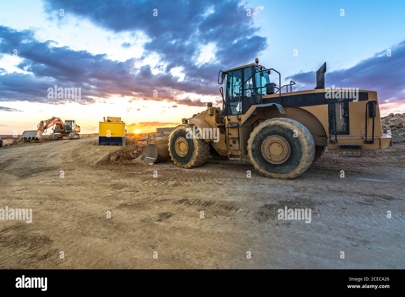 Bulldozer on roadside of unpaved highway Stock Photo - Alamy
